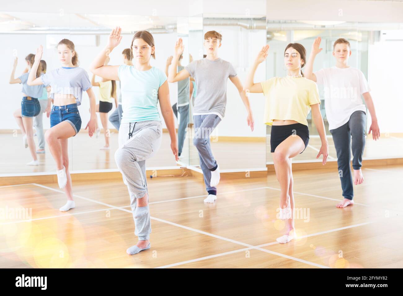 Positive teenage dancers doing dance workout during group class Stock ...