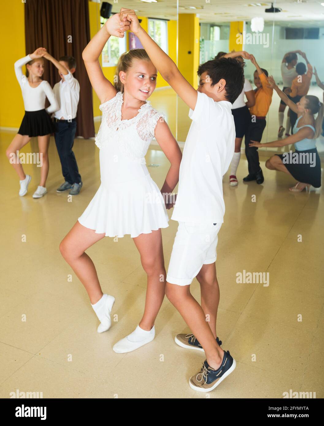 Boys and girls in dance studio learning new movements, smiling and ...