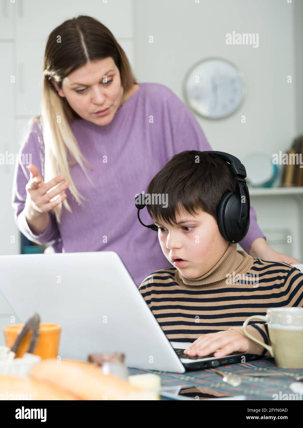 Upset mother arguing with son who plaing video games in domestic ...