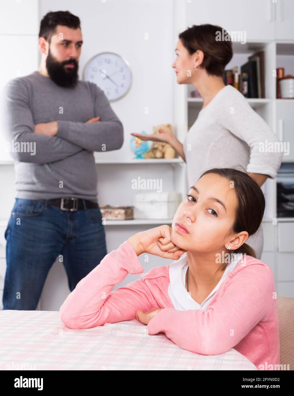 Young parents arguing with each other while their daughter at home ...