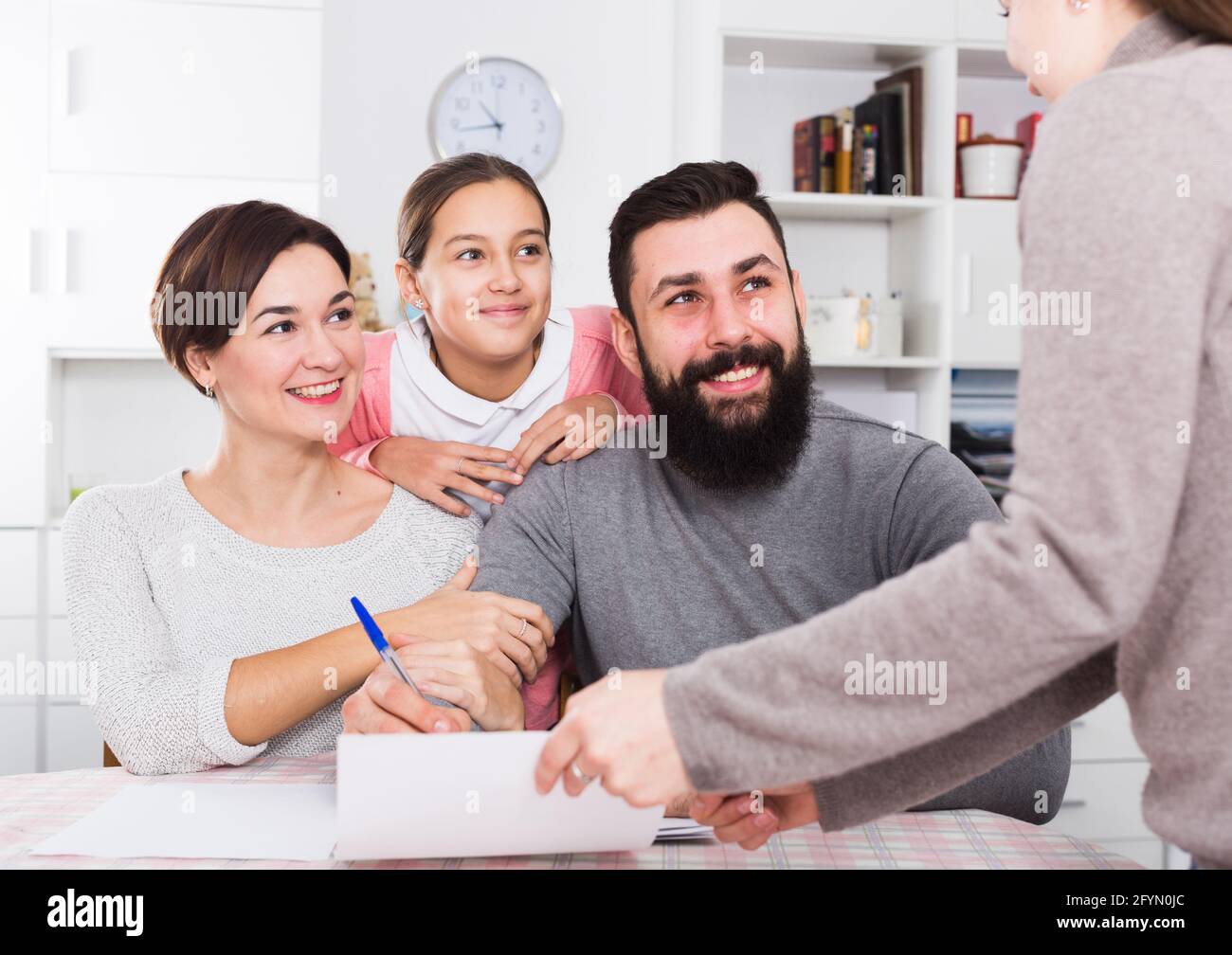 Young parents signing papers for new house with their daughter Stock ...
