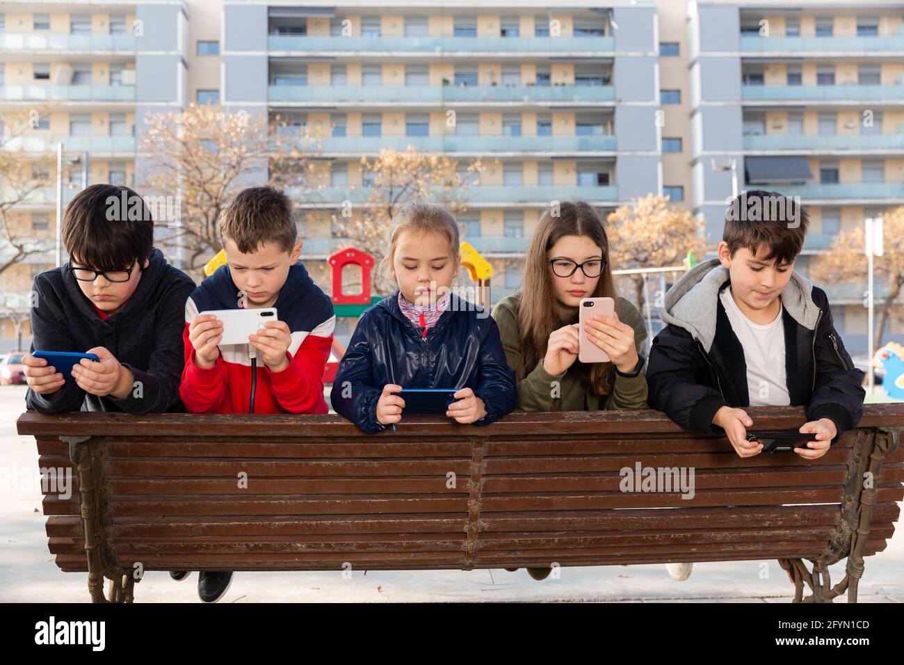 Group of children communicate using smartphones in the playground Stock ...