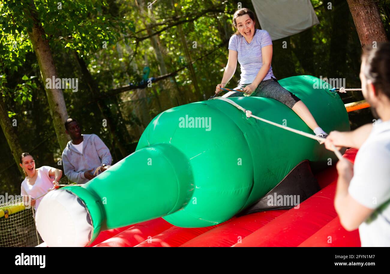 Fun attraction - woman trying to stay on an inflatable bottle Stock ...