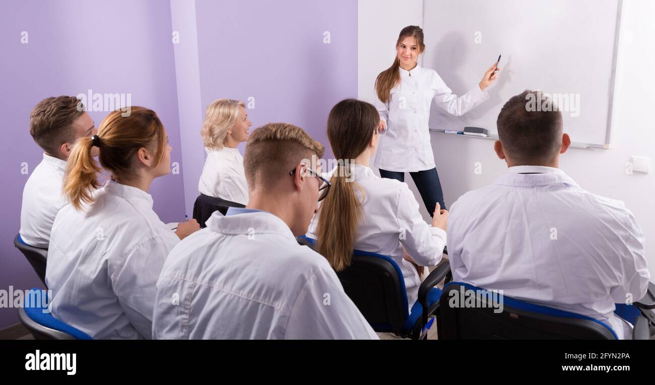 Girl medical student lecturing near whiteboard in front of teacher and ...