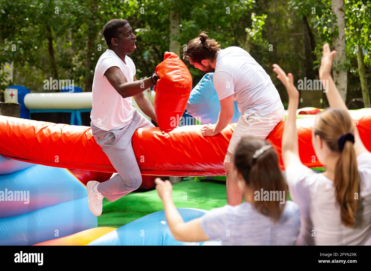 Cheerful pillow fight sitting on a log in an amusement park Stock Photo ...