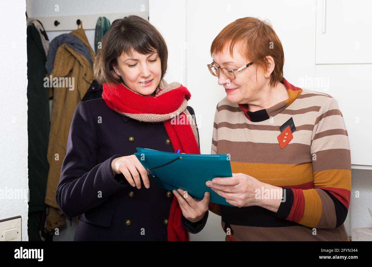 Mature woman answer questions of young employee Stock Photo - Alamy