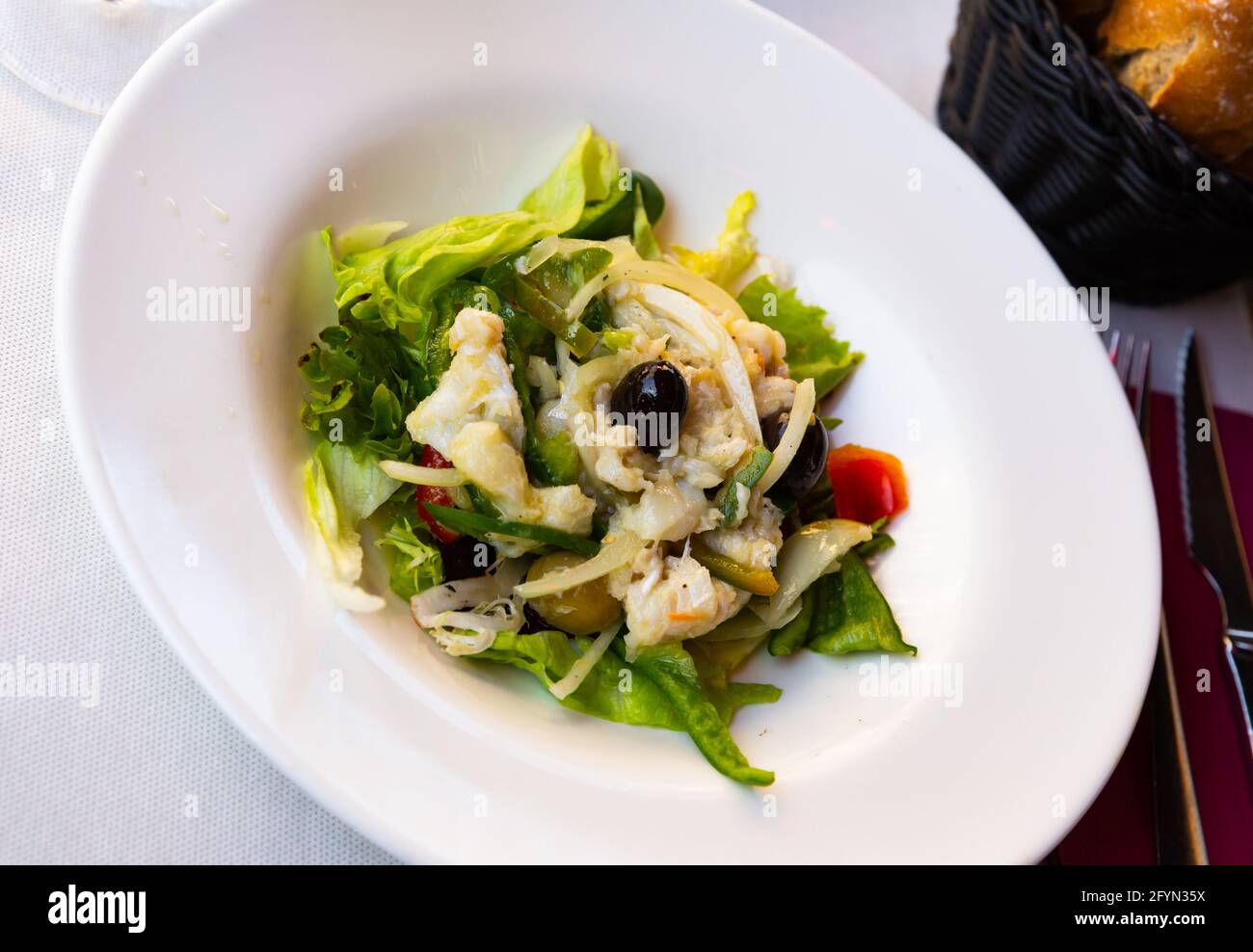 Typical Catalan dish Esqueixada, salad with shredded cod, tomatoes ...