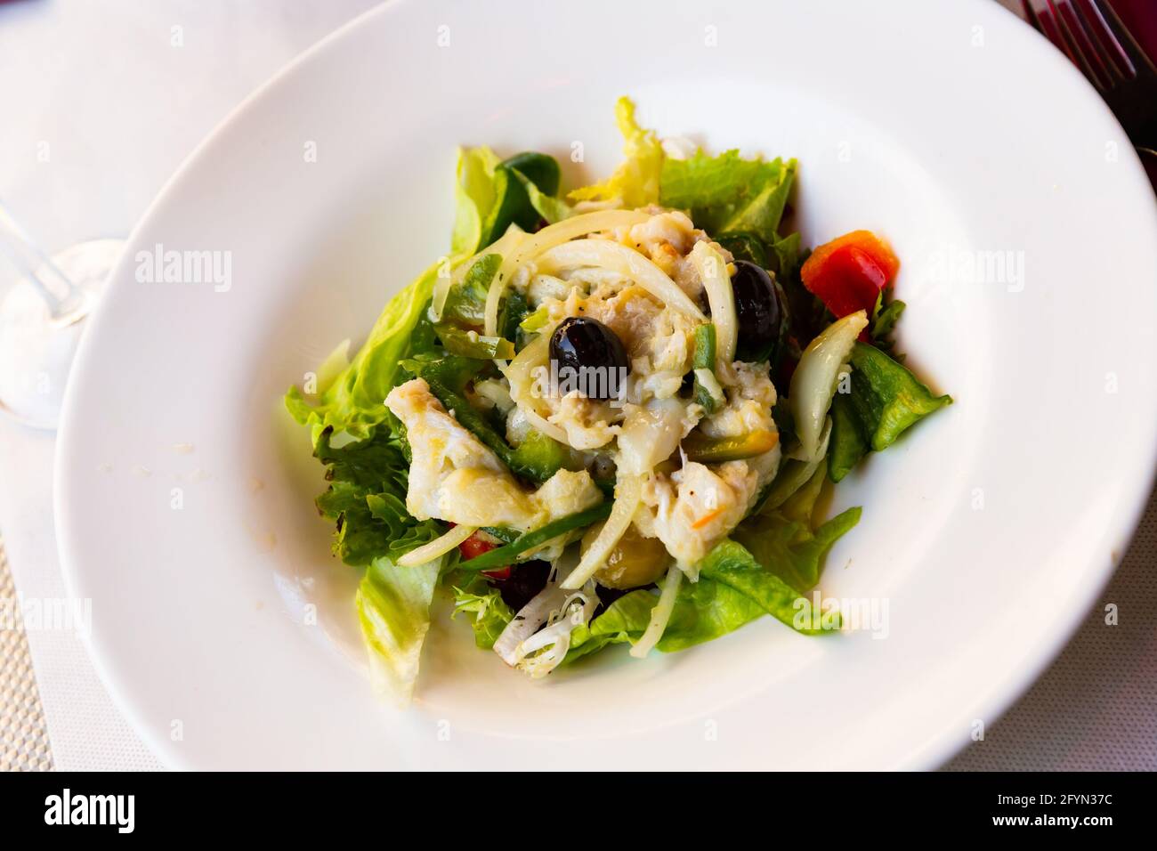 Typical Catalan dish Esqueixada, salad with shredded cod, tomatoes ...