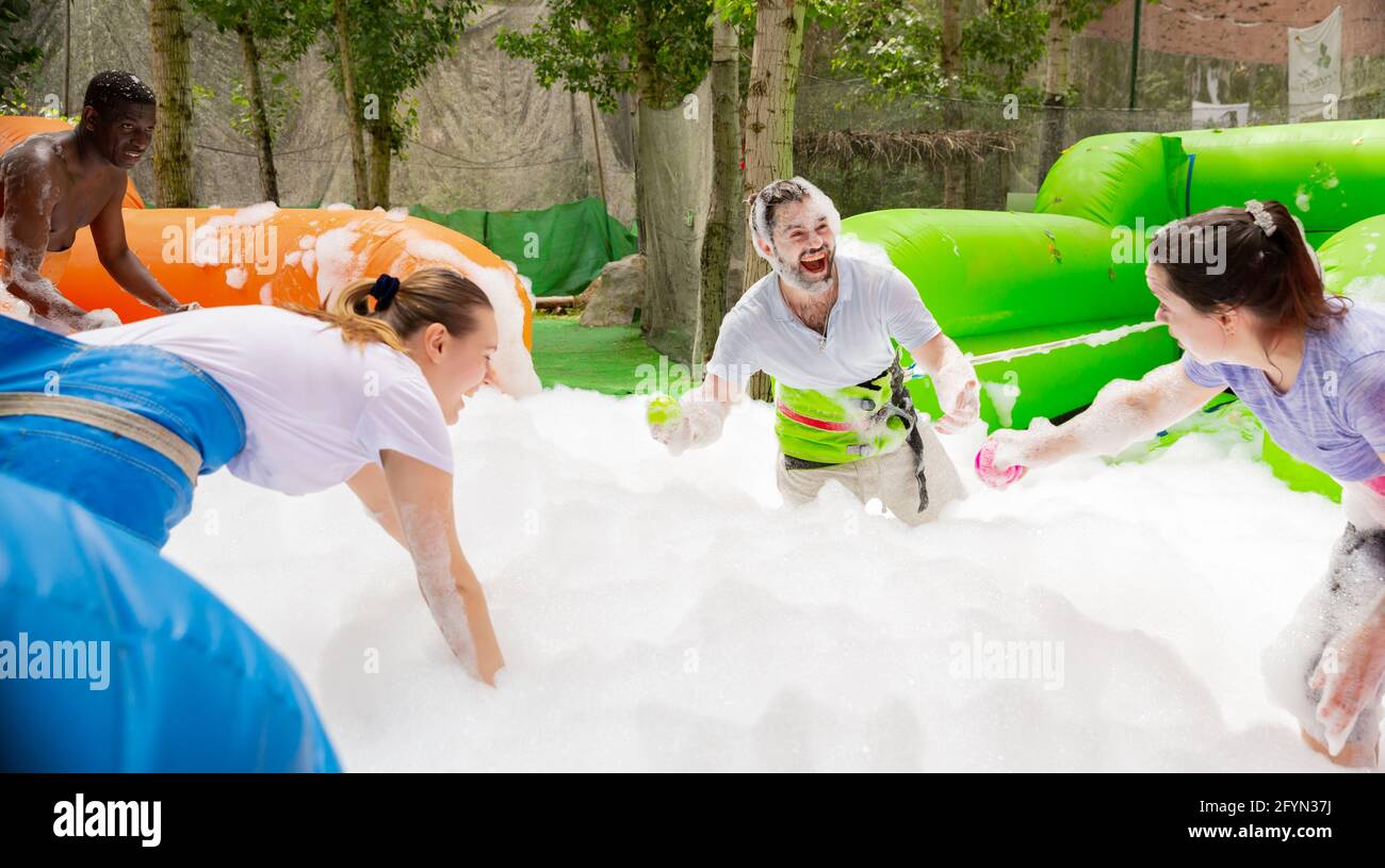 Game of funny friends in soap suds on an inflatable trampoline Stock ...