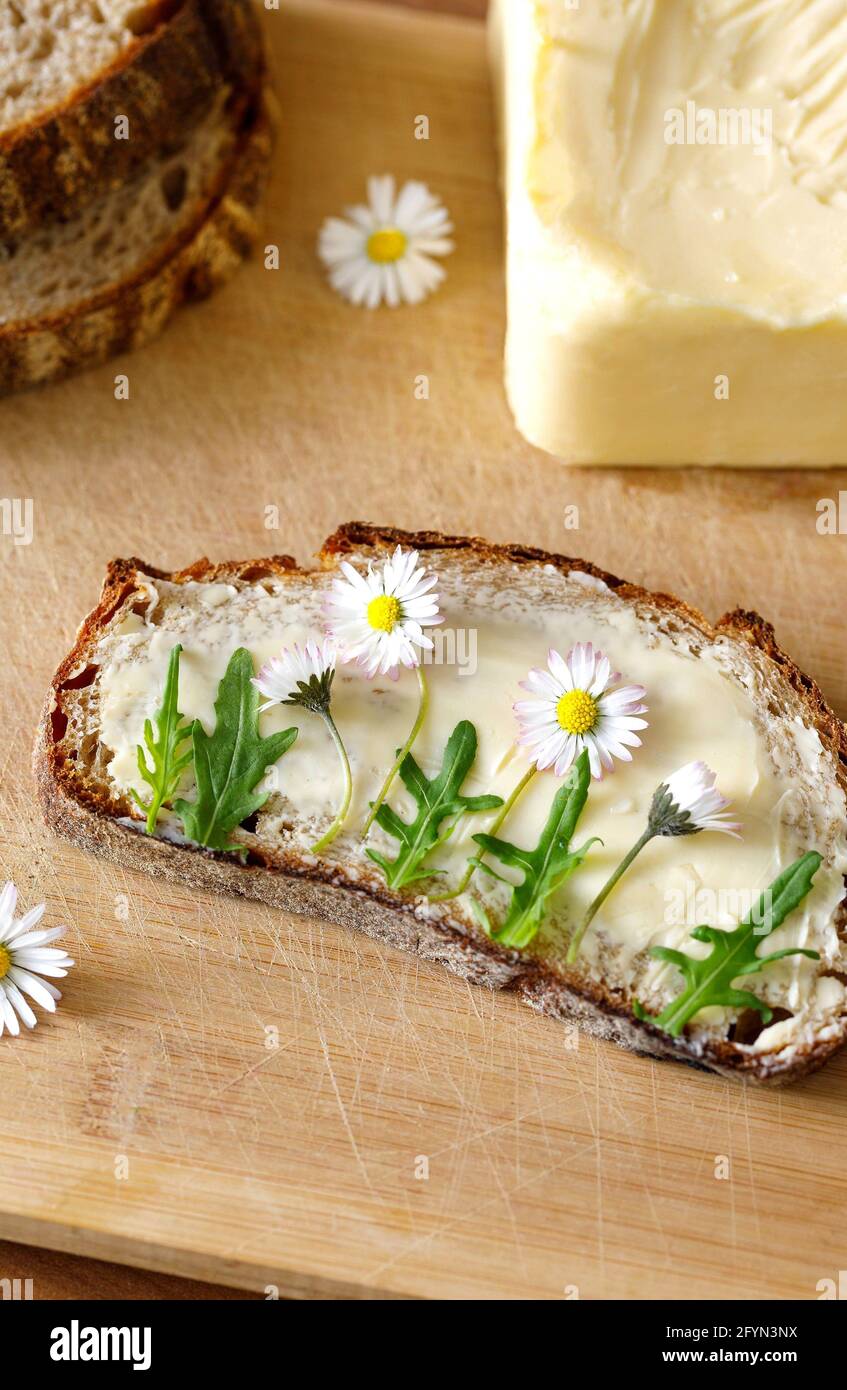 Bread Slice with butter Daisys Ruccola on a wooden Table Stock Photo ...