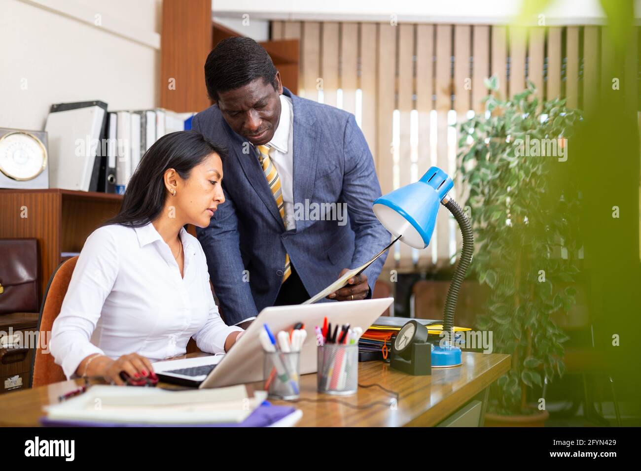 Portrait of two colleagues solving business issues while working in ...