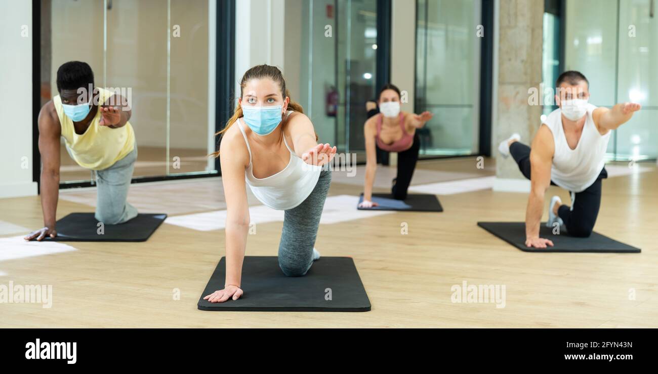 Sporty girl wearing protective mask to prevent viral infections doing ...