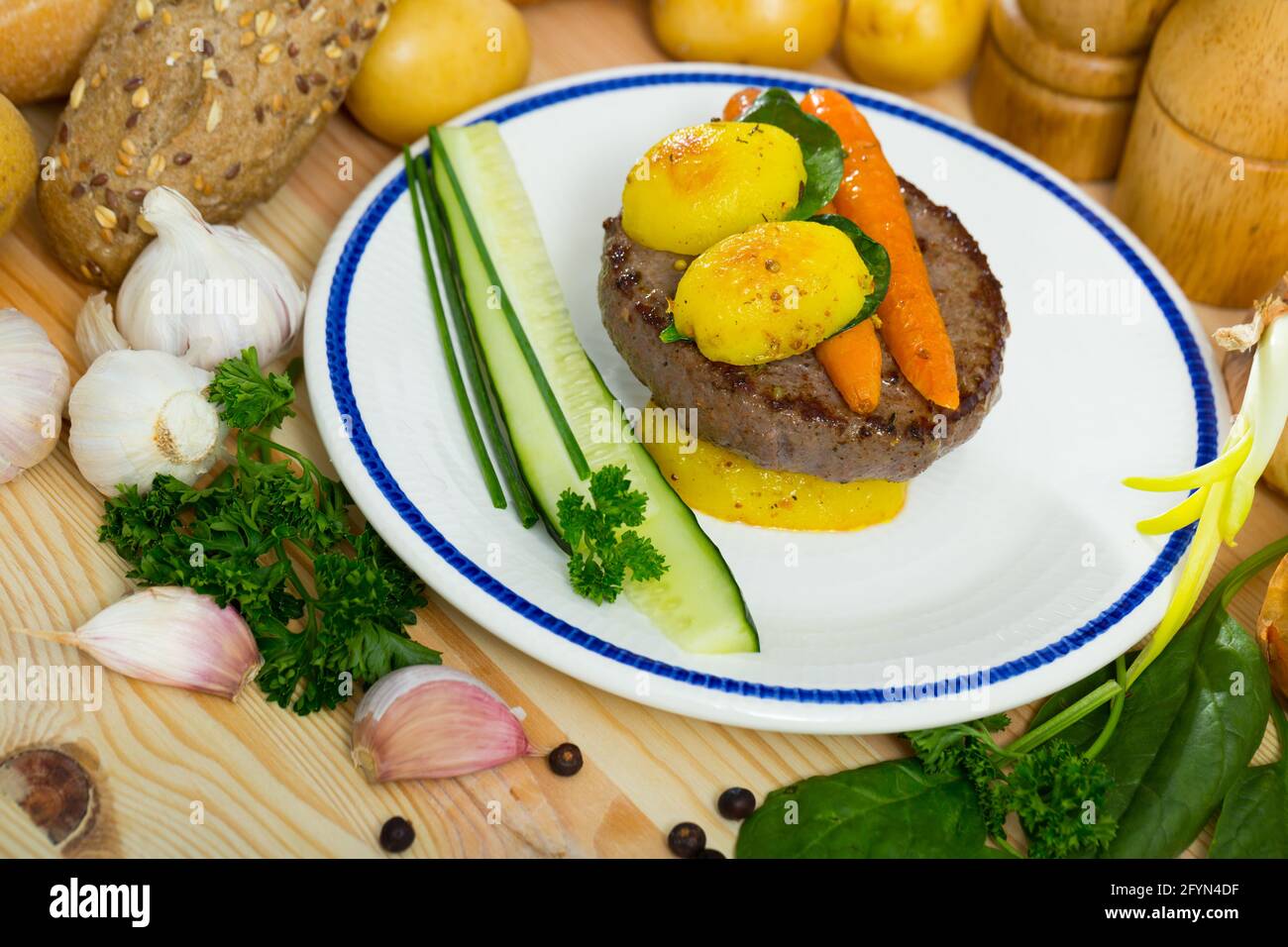 Delicious beef rissole with garnish of roasted new potatoes, baked ...