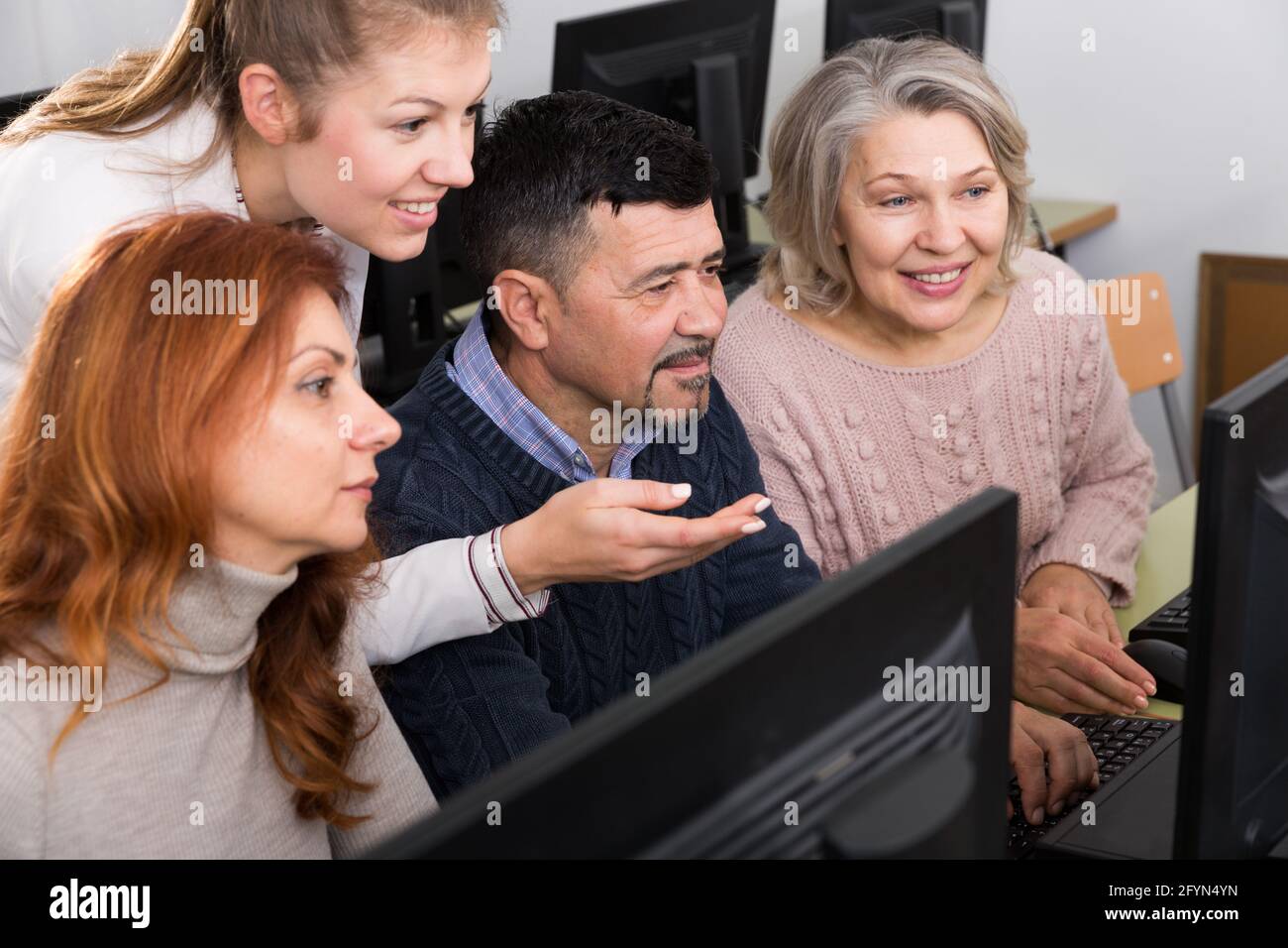 Business people grouped around laptop hi-res stock photography and ...