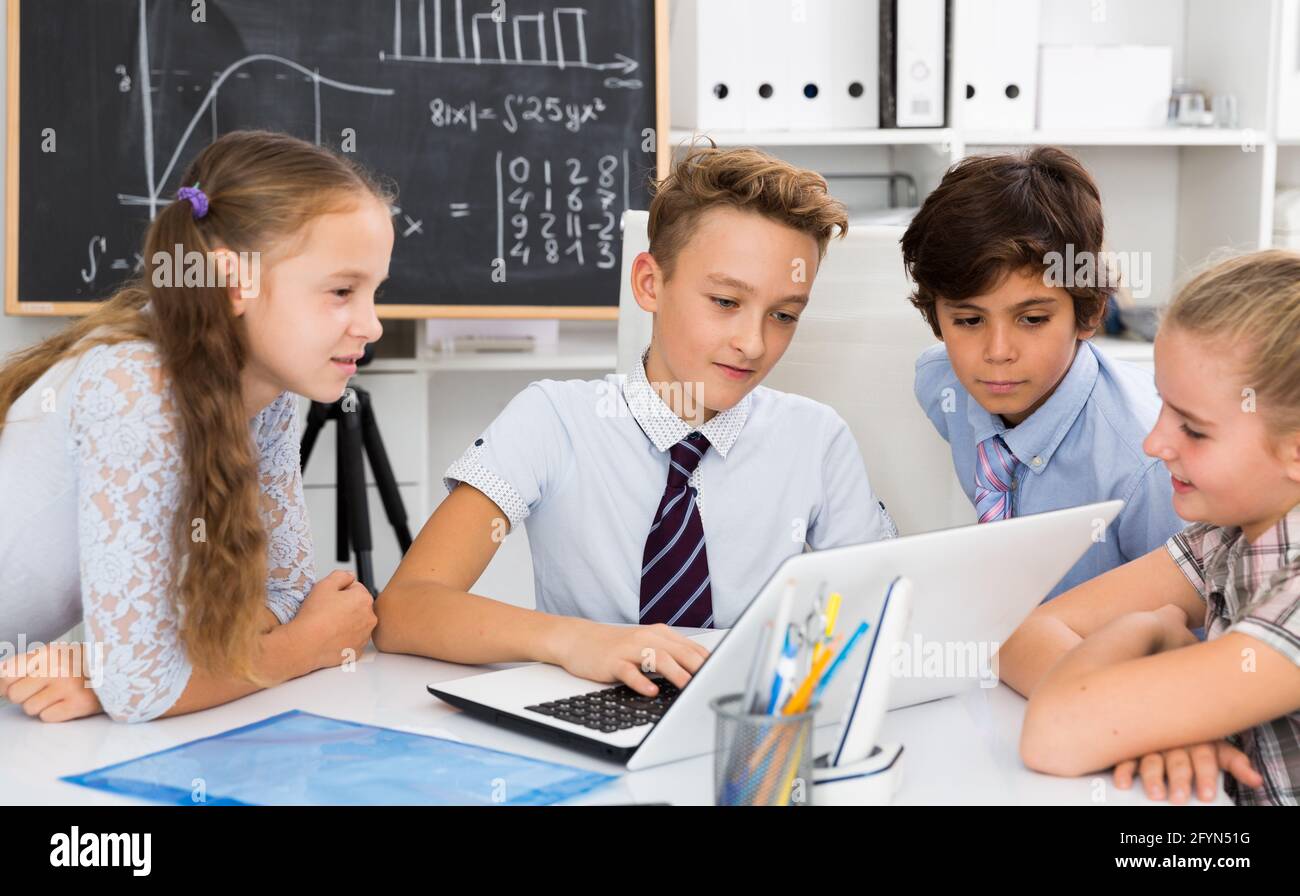 Group of children near laptop talking about mathematics indoors Stock ...