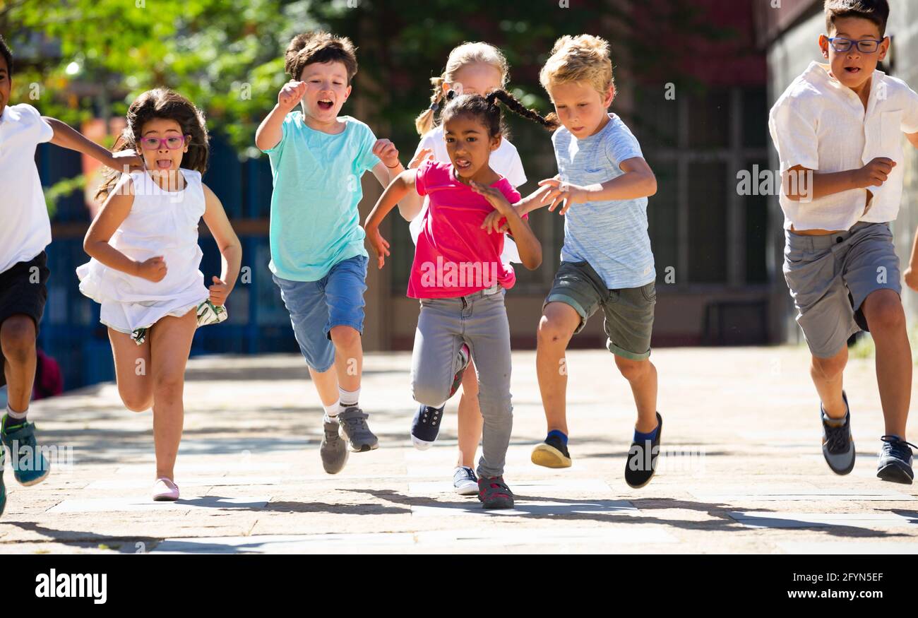 Group of happy kids running in race in the street and laughing outdoors ...