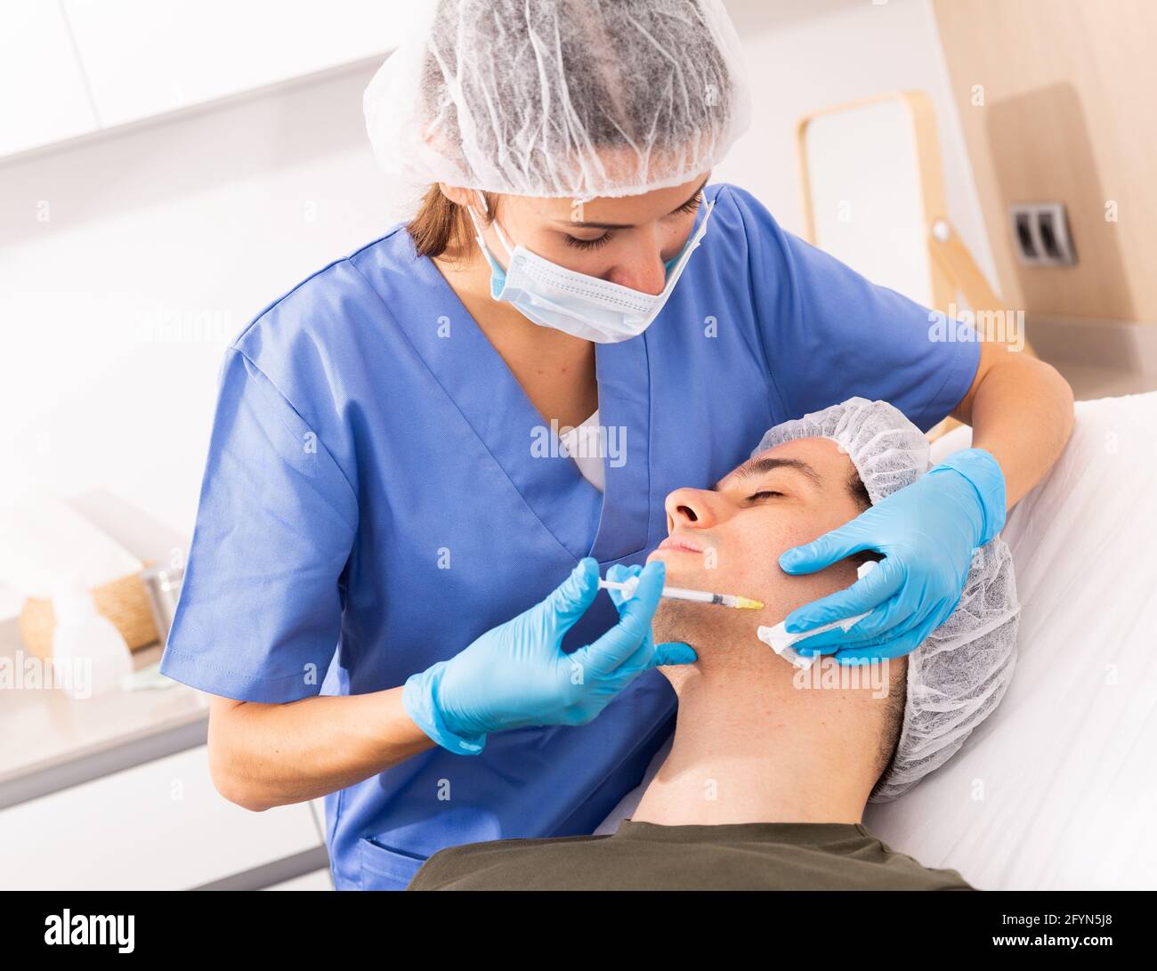 Confident woman doctor giving injections with syringe for facial ...