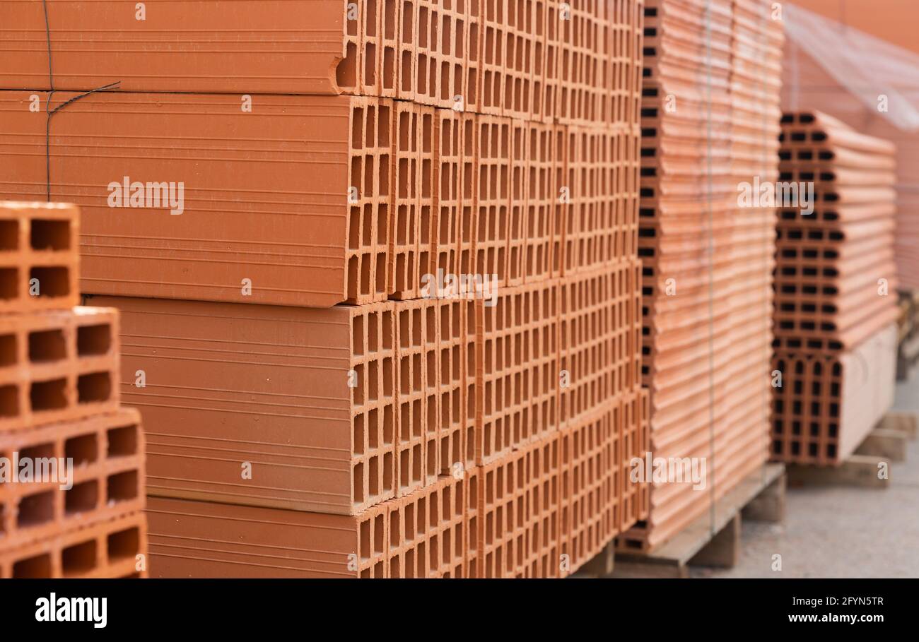 Pallets with stack of redbricks lying at warehouse of building ...