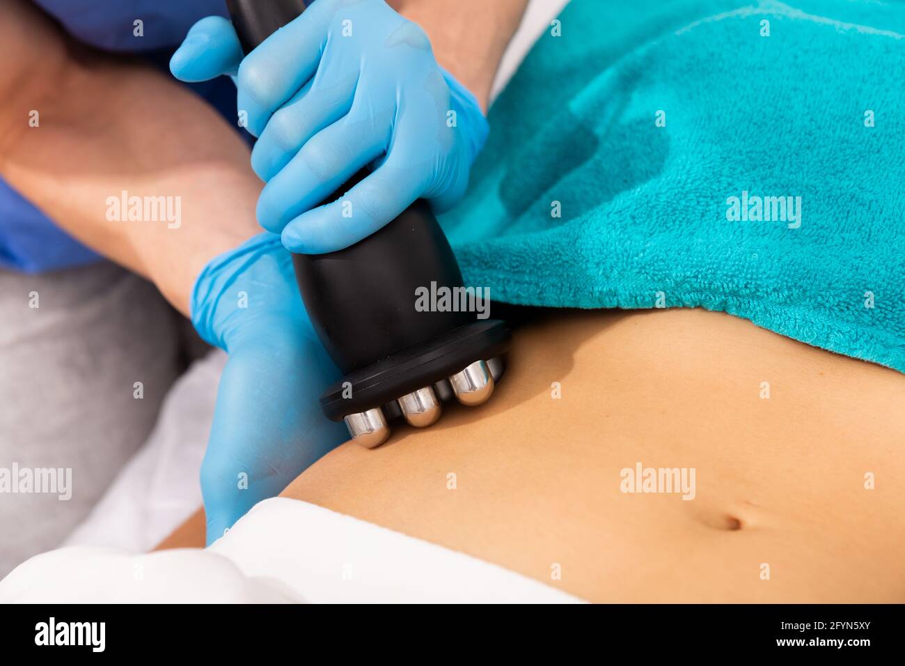 Closeup of female abdomen during ultrasonic fat cavitation procedure at ...