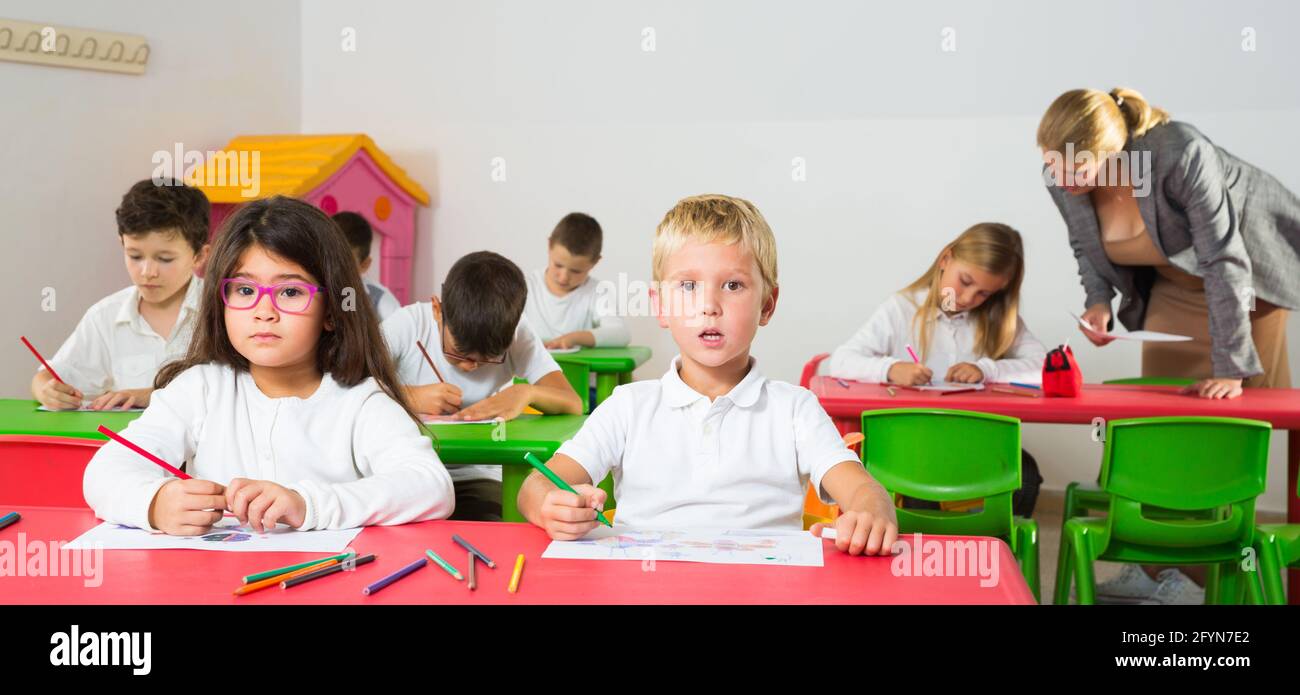 Portrait of surprised little pupils at lesson in classroom at ...