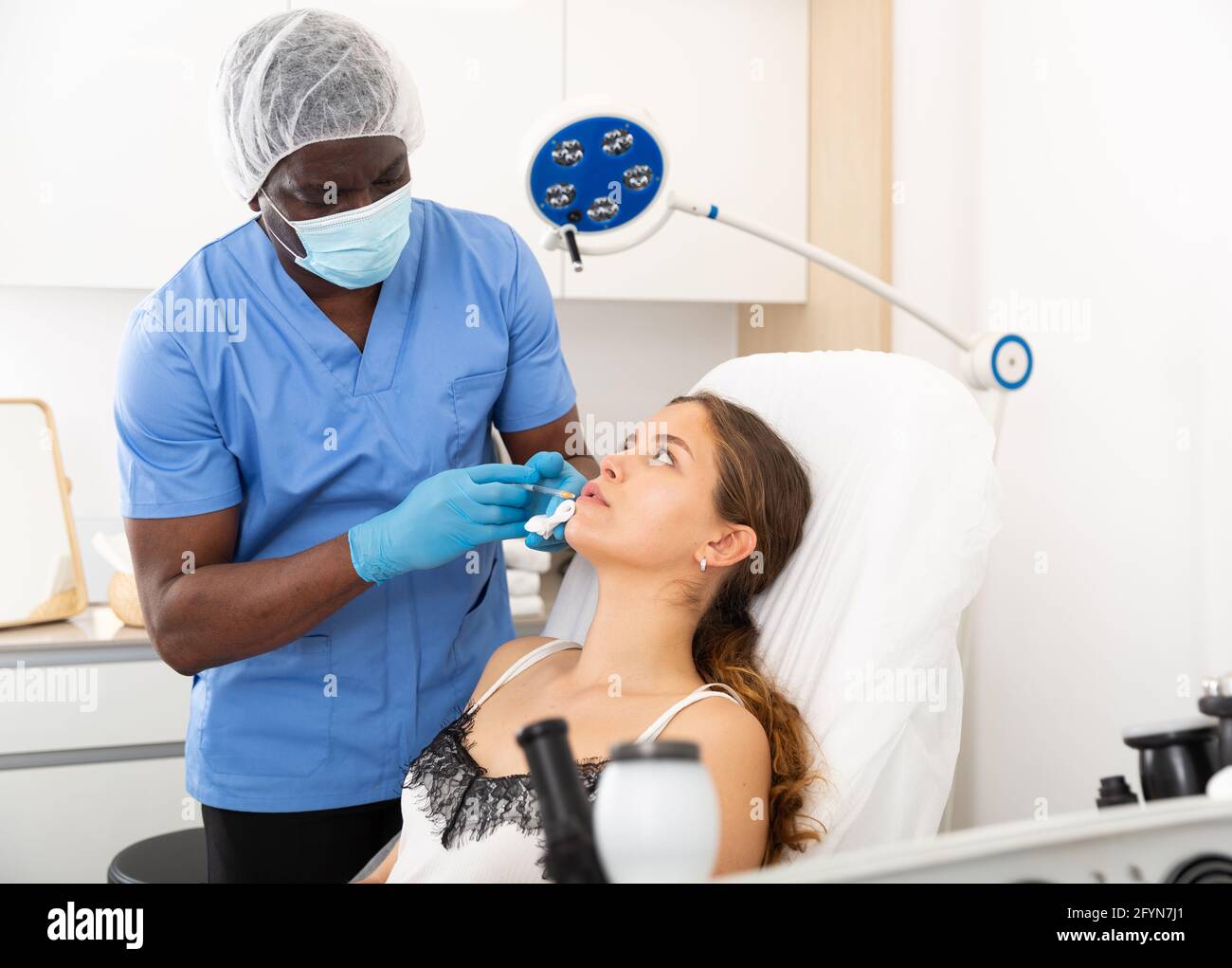 Professional African American male beautician performing face ...