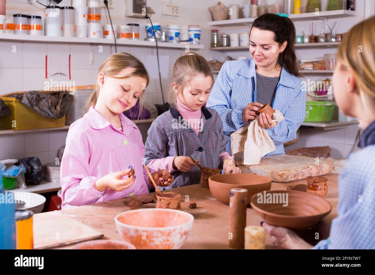Smiling students are trying to make the first works of clay in the ...
