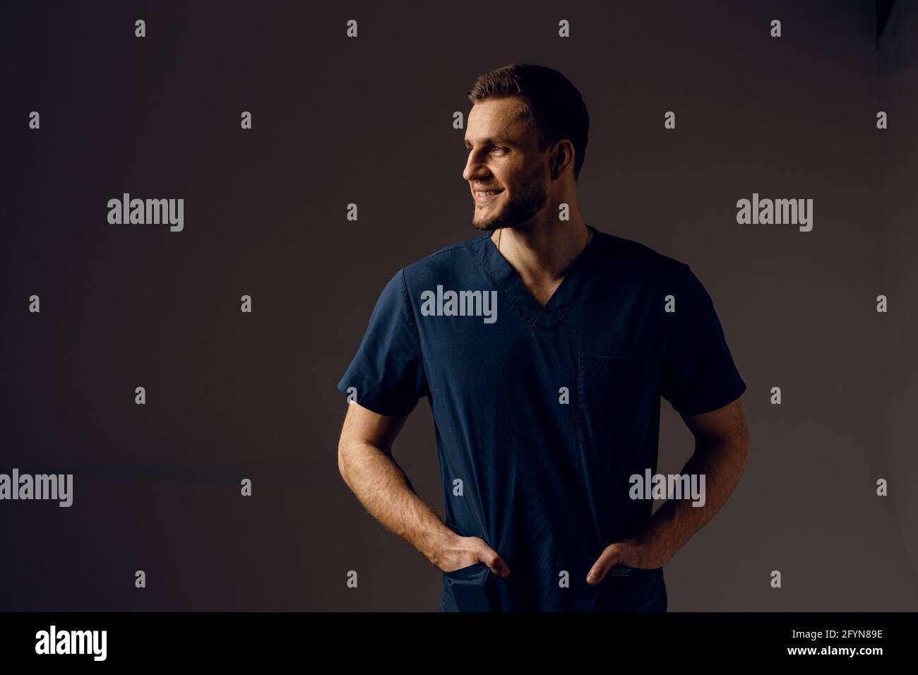 Surgeon weared in medical robe on dark background. Handsome doctor ...