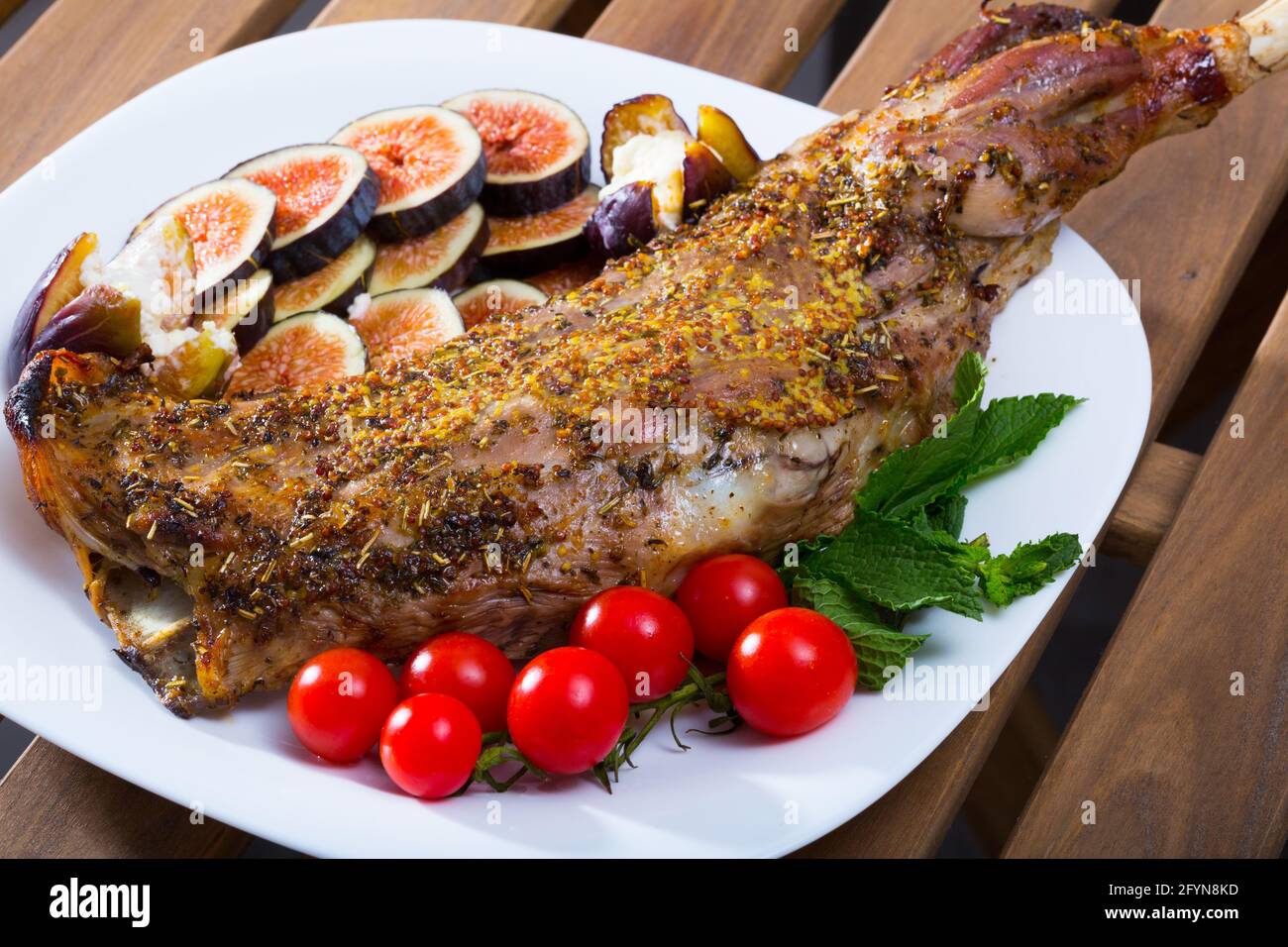Gigot baked in oven with honey, served with fig, Feta cheese and herbs ...