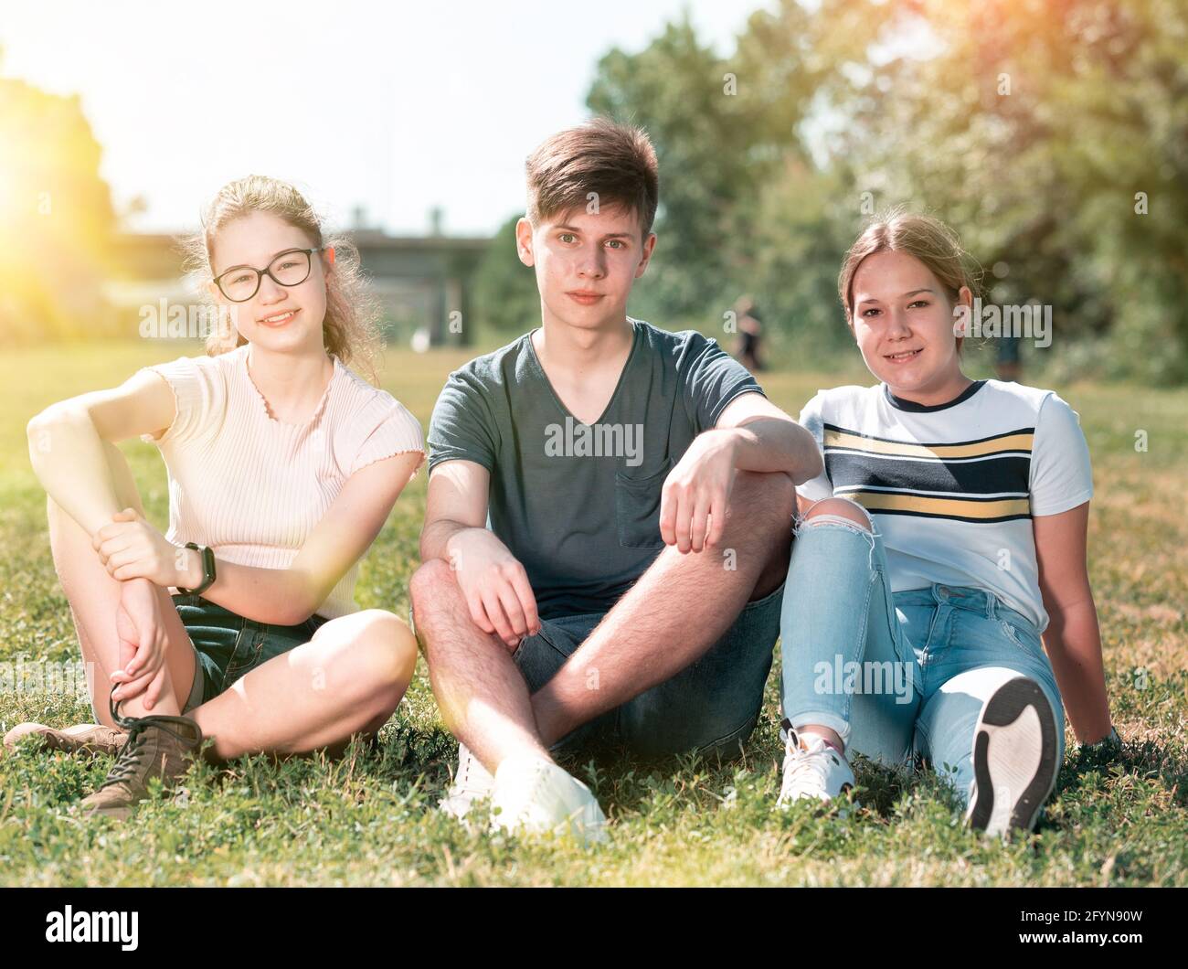 Portrait of positive teenagers on the summer green lawn Stock Photo - Alamy