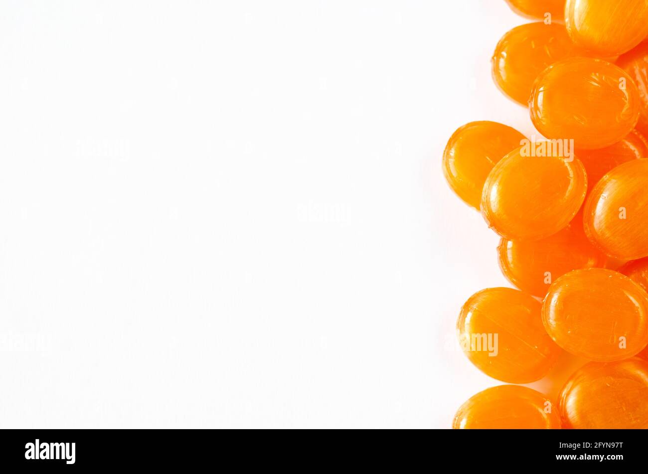 Closeup of hard sucking fruit candies on a white background. Orange ...