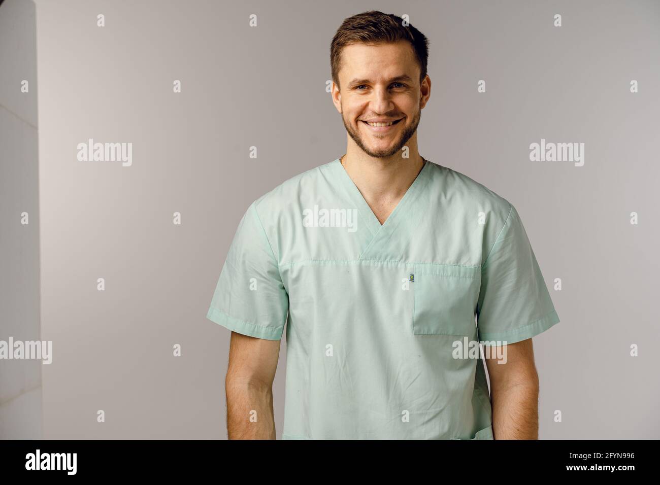 Surgeon weared in medical robe smile and posing on white background ...