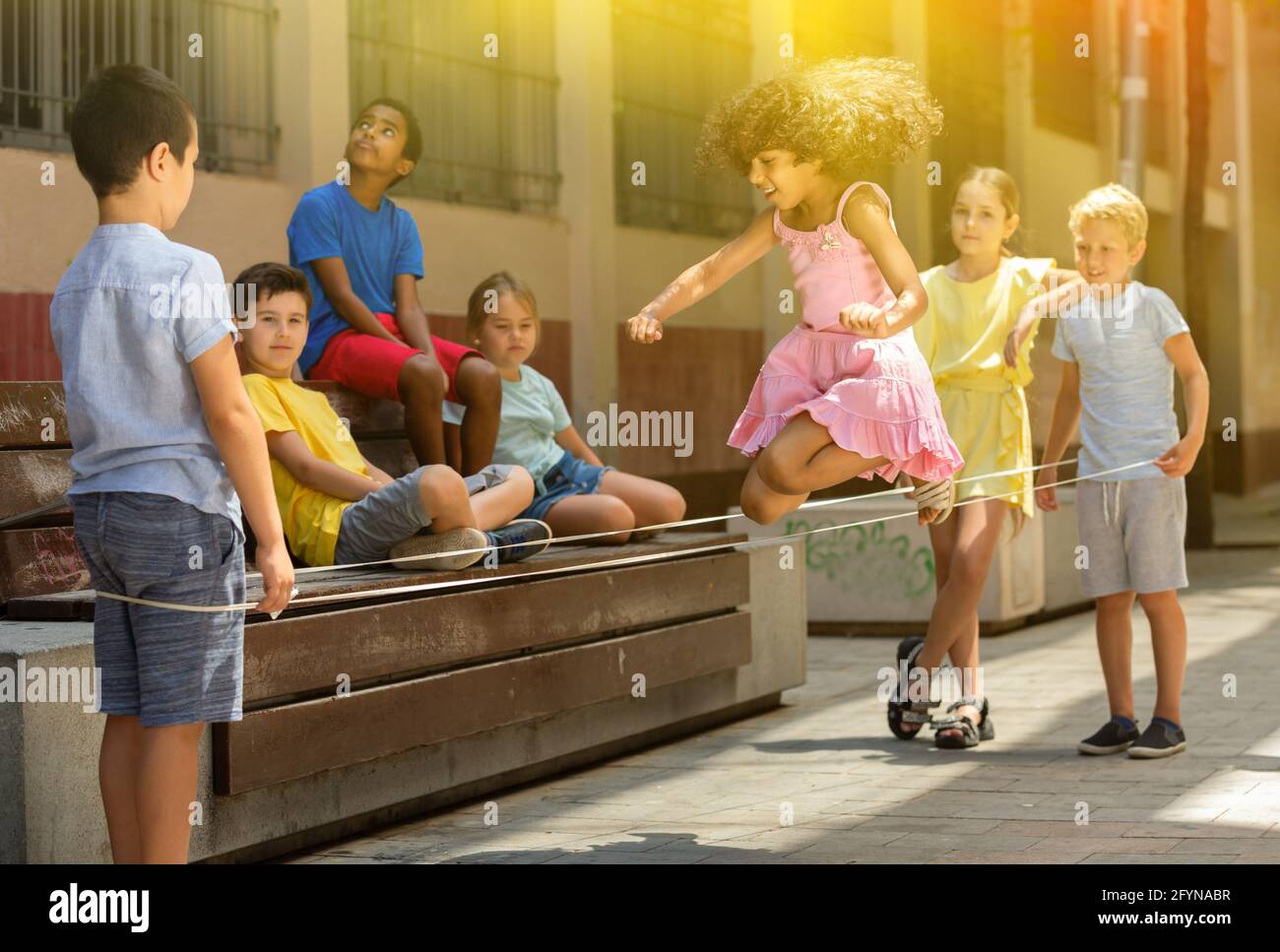 Happy peruvian little girl jumping game by rubber band with european ...