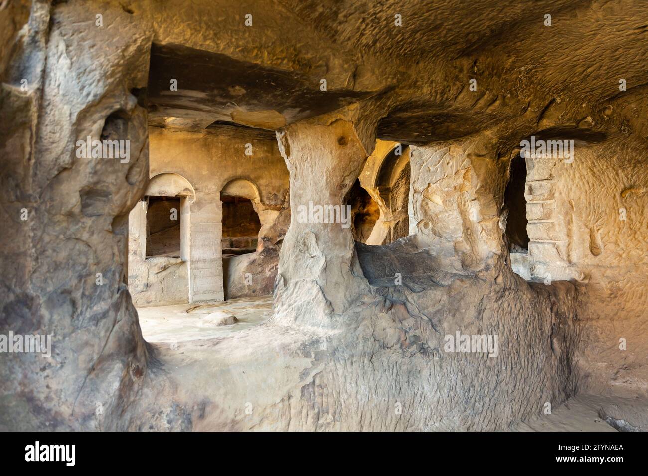 Interior of cave halls carved into mountain with pillars supporting ...