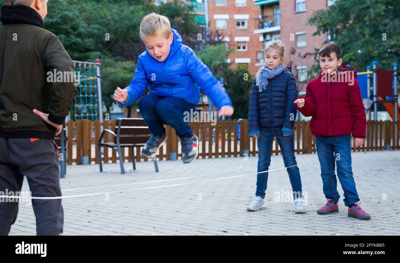 Children jump through an elastic rope in a children playground Stock ...