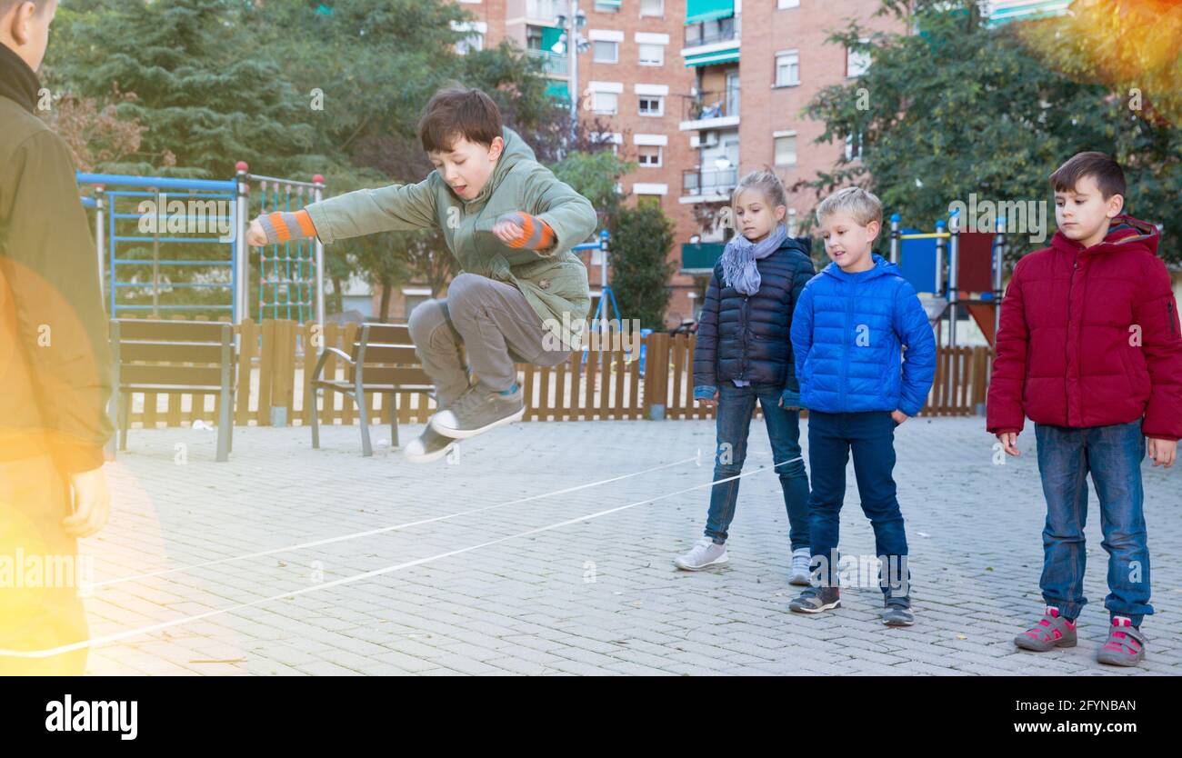 Children jump through an elastic rope in a children playground Stock ...