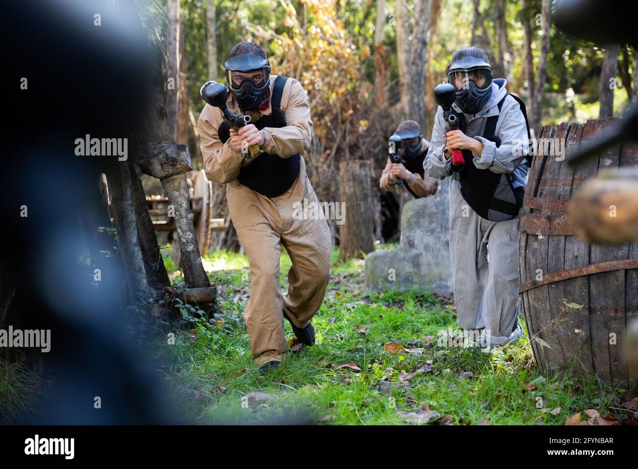 Group of people in full gear playing paintball on shooting range Stock ...
