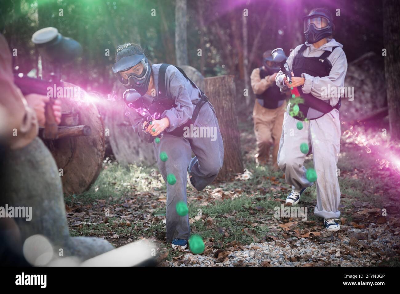 Teams of friends facing on battlefield in outdoor paintball arena ...