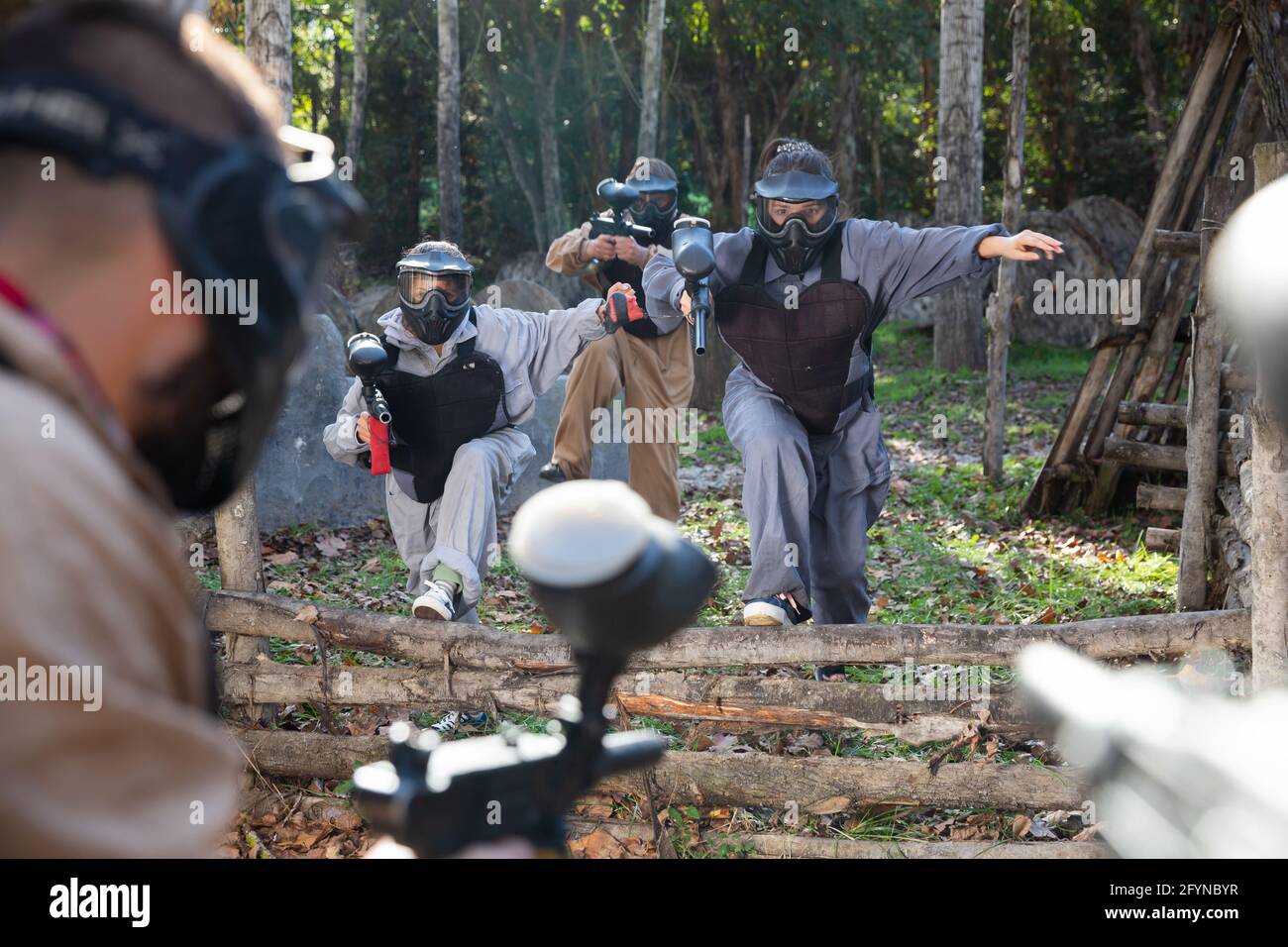 Group of people in full gear playing paintball on shooting range Stock ...
