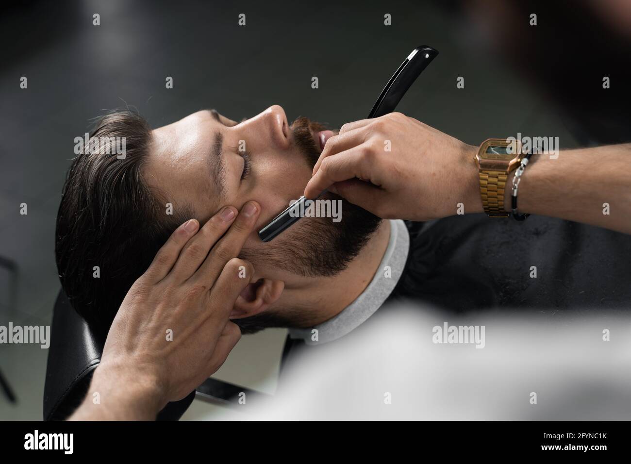 Straight razor cut mans beard in barbershop. Barber man making ...