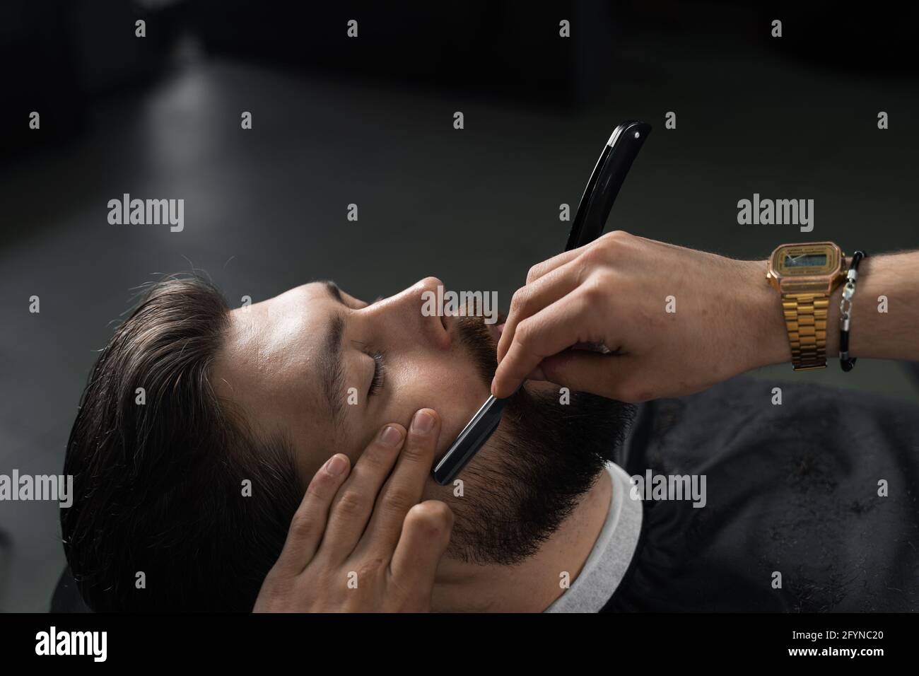 Straight razor cut mans beard in barbershop. Barber man making ...