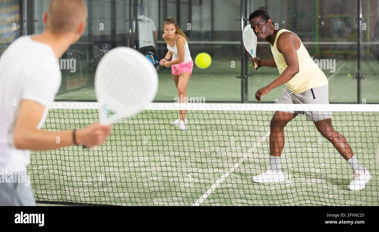 Padel players, man and woman, playing a match on the court at fitness ...