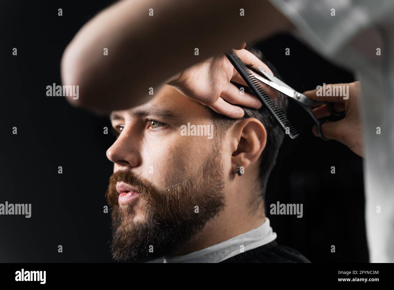 Barber making hairstyle for confident bearded hipster. Advertising for ...