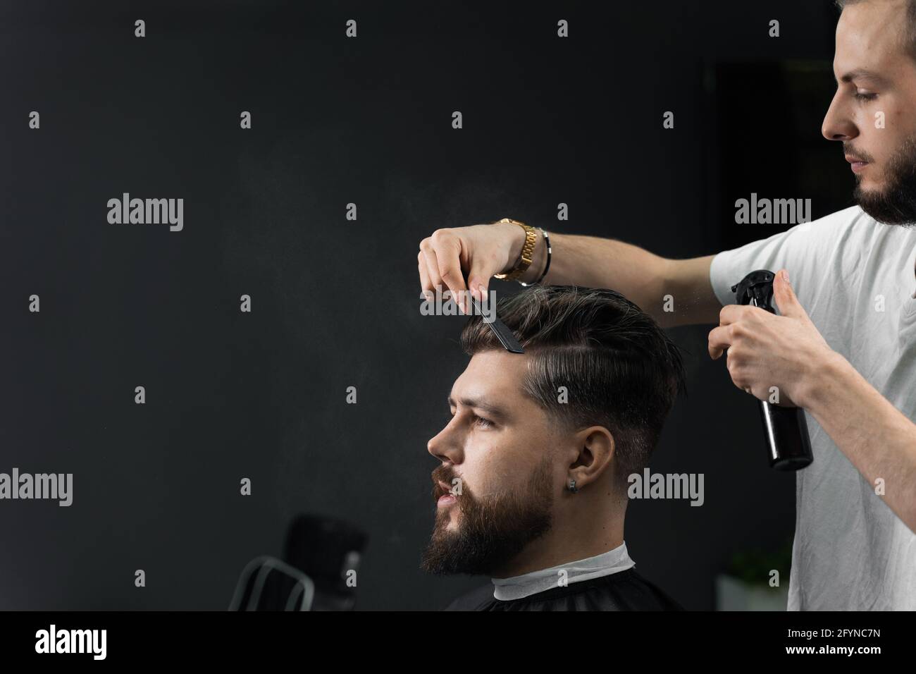 Low fade machine haircut for handsome bearded man in barbershop. Barber ...