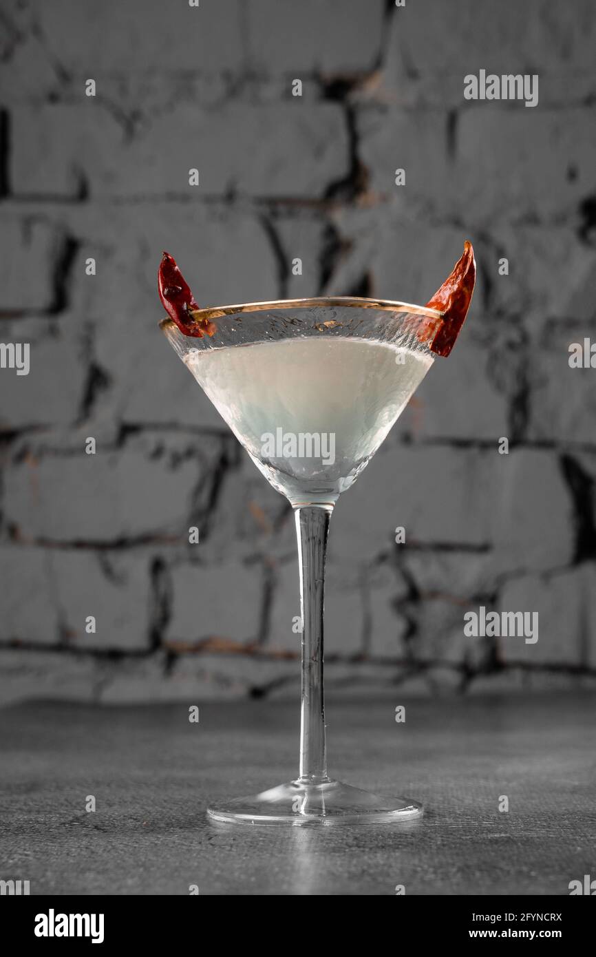 Cocktail in glass with chili on gray background. Devil alcohol drink ...
