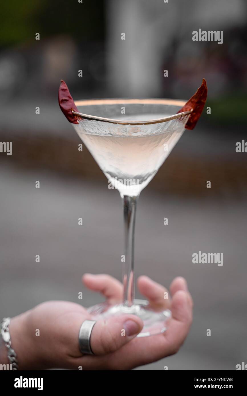 Cocktail in glass with chili on gray background. Devil alcohol drink ...