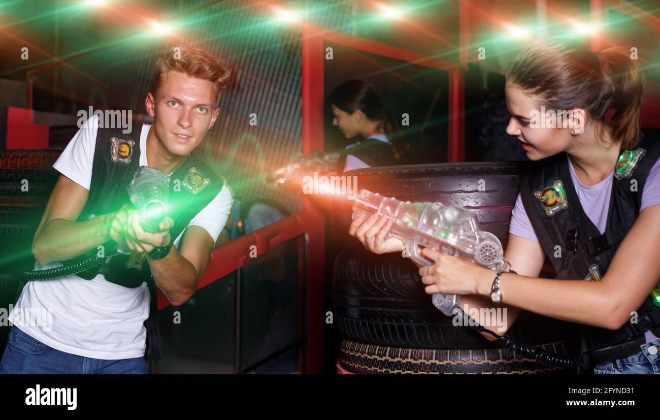Group portrait of glad emotional people with laser guns playing laser ...
