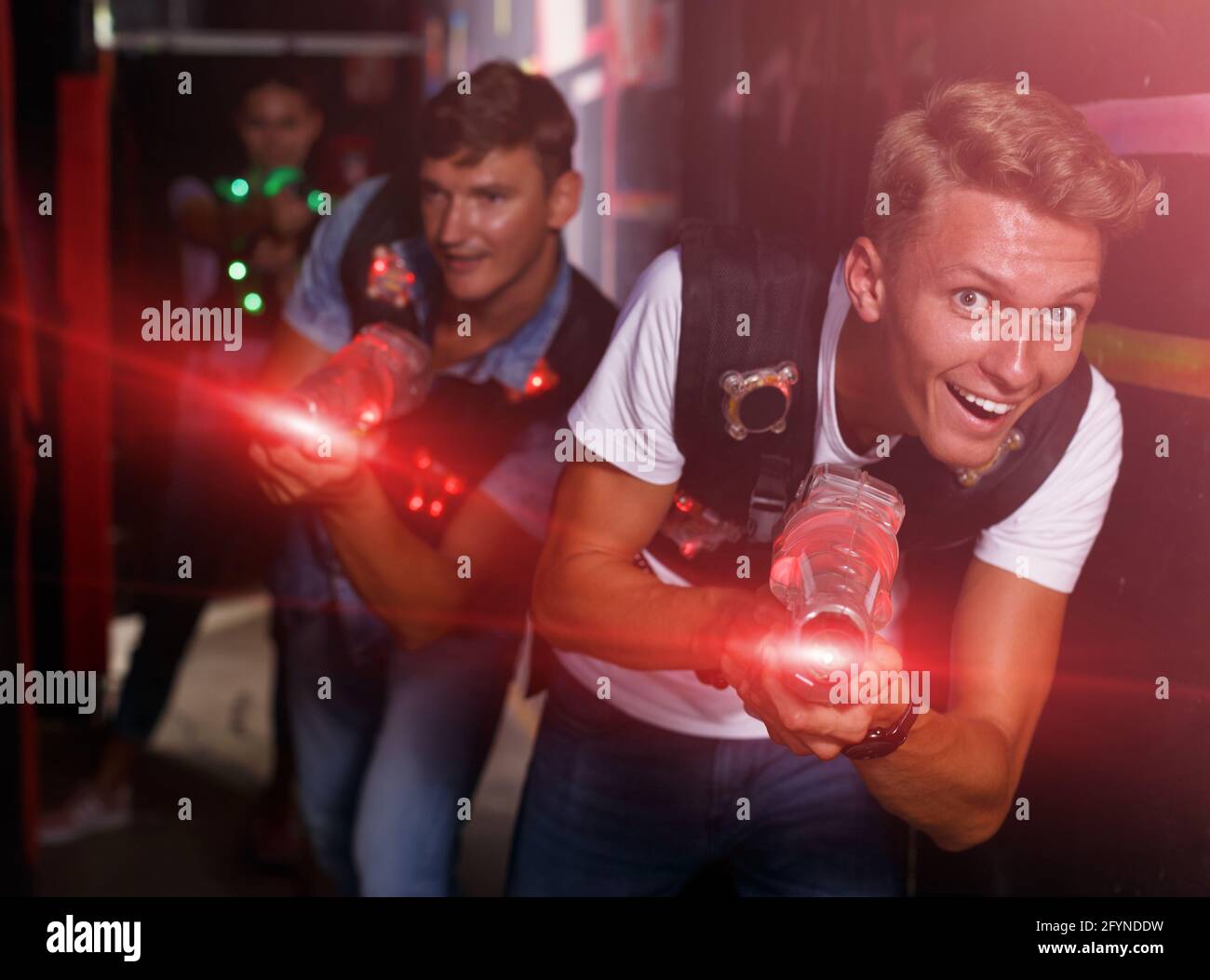 young man with laser gun took aim in dark labyrinth during laser tag ...