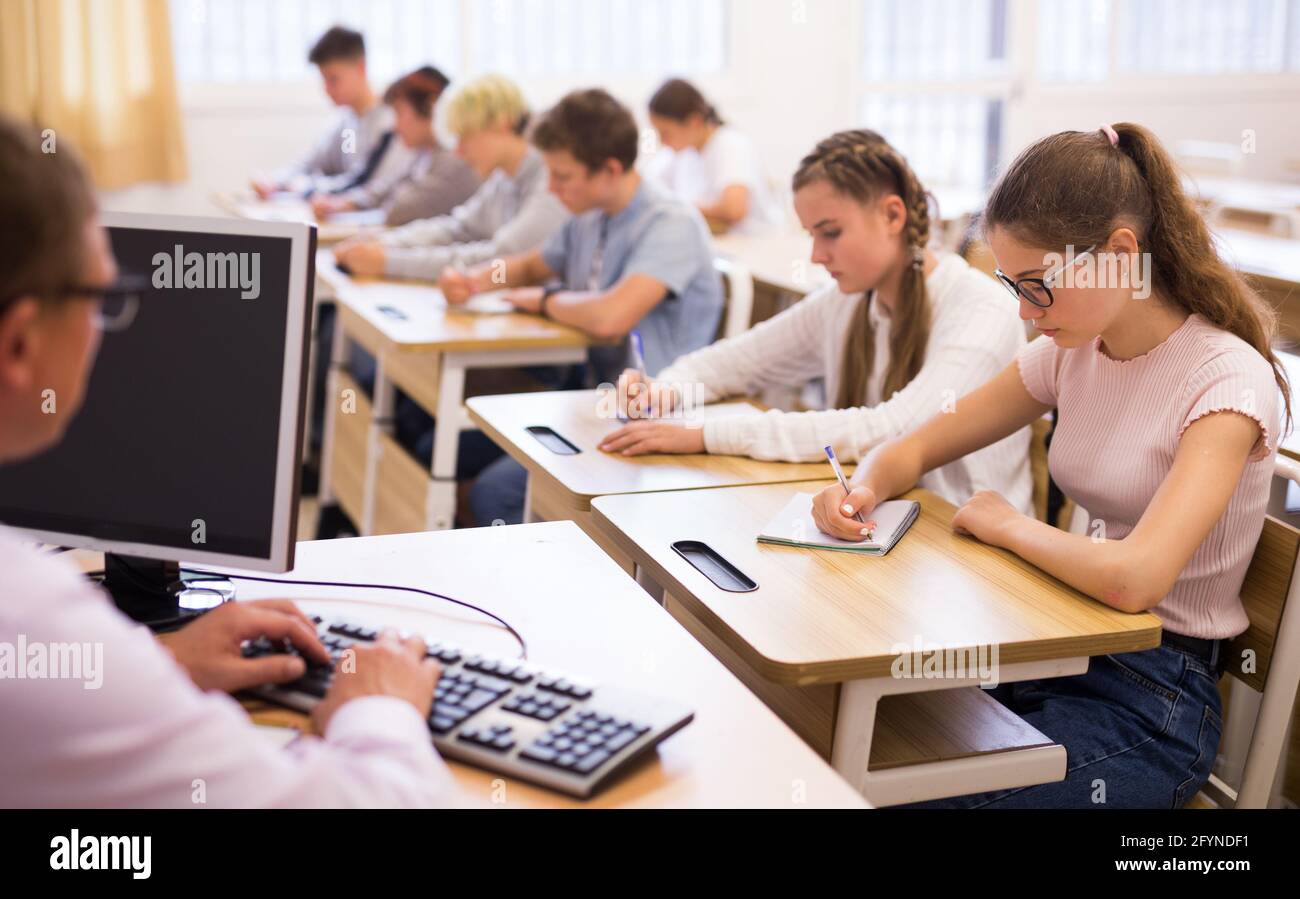 Multiracial group of teenage students working at class, listening ...