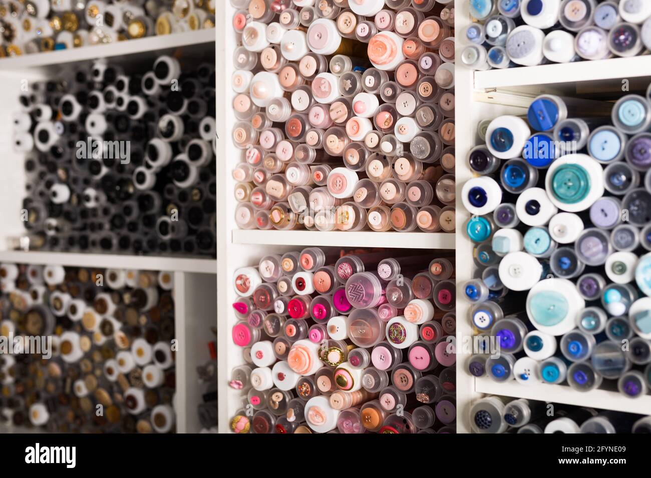 Colorful buttons from metal, wood and plastic on showcase shelves in ...