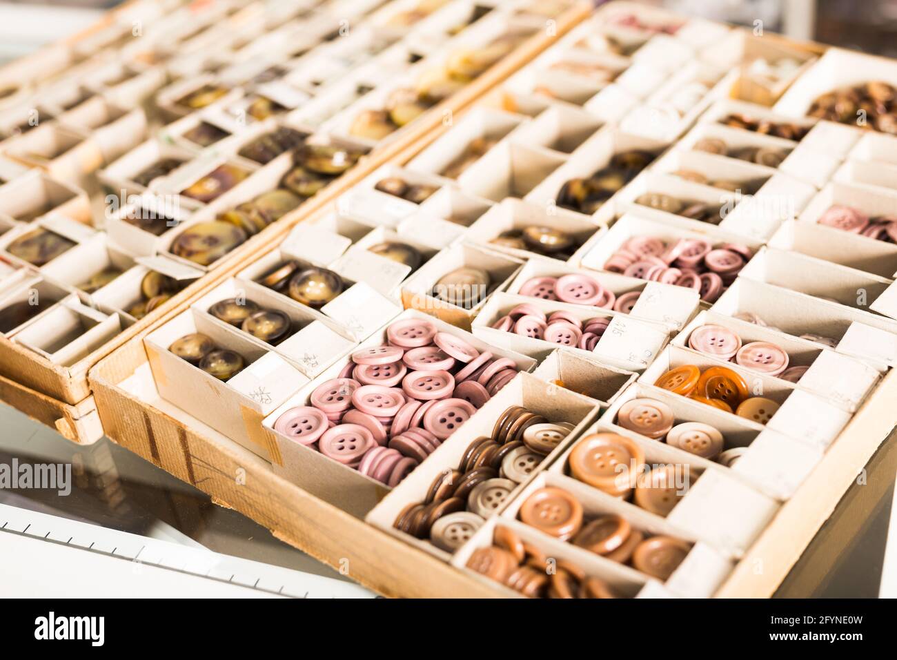 Various flat buttons for clothes in carton boxes on counter in sewing ...